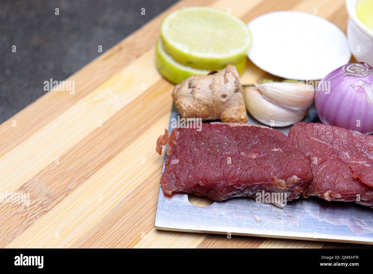 cow beef with spice and sliced lemon and tomato on chopping board Stock ...