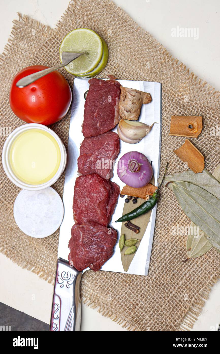 cow beef with spice and sliced lemon and tomato on chopping board Stock ...
