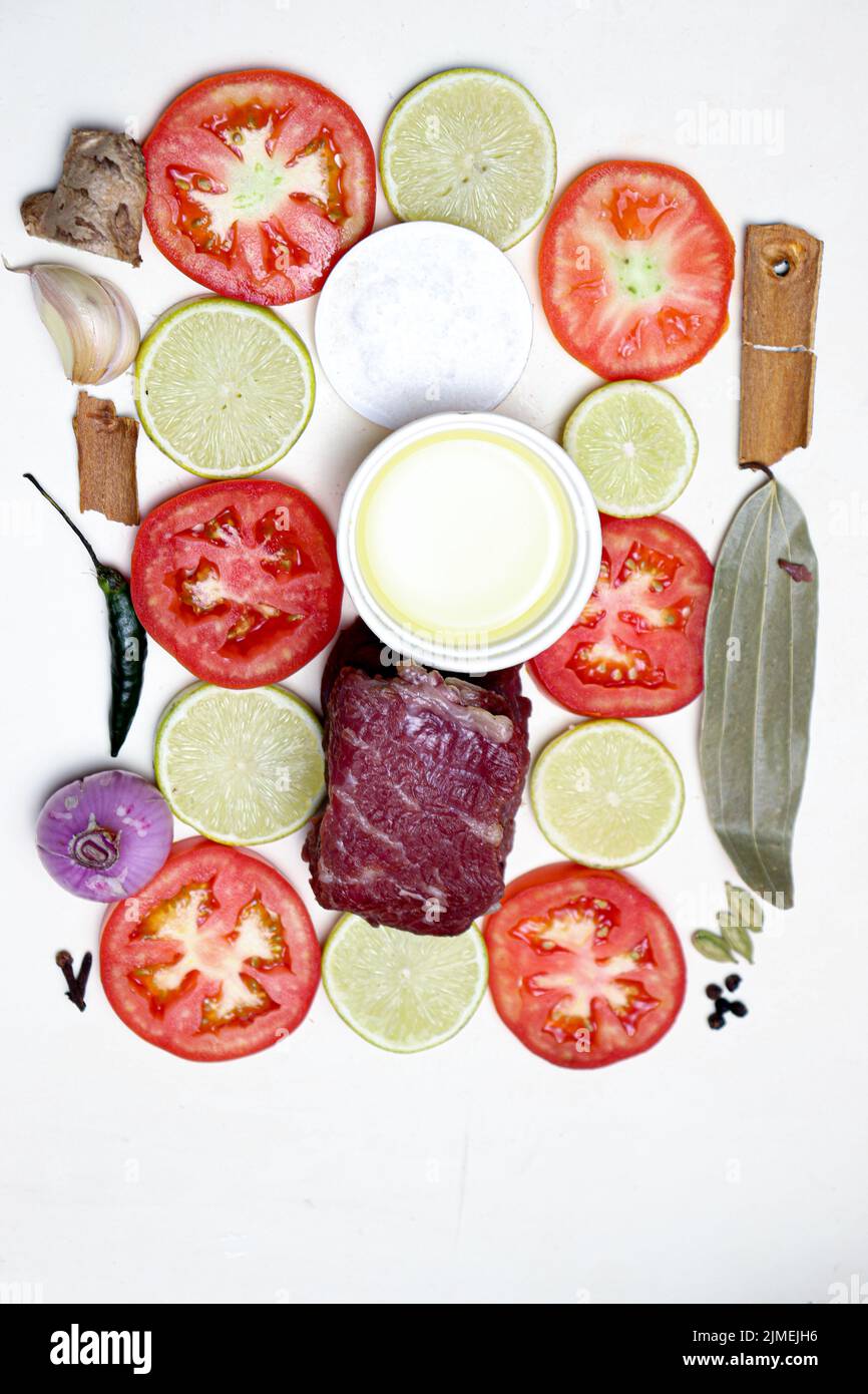cow beef with spice and sliced lemon and tomato on chopping board Stock ...