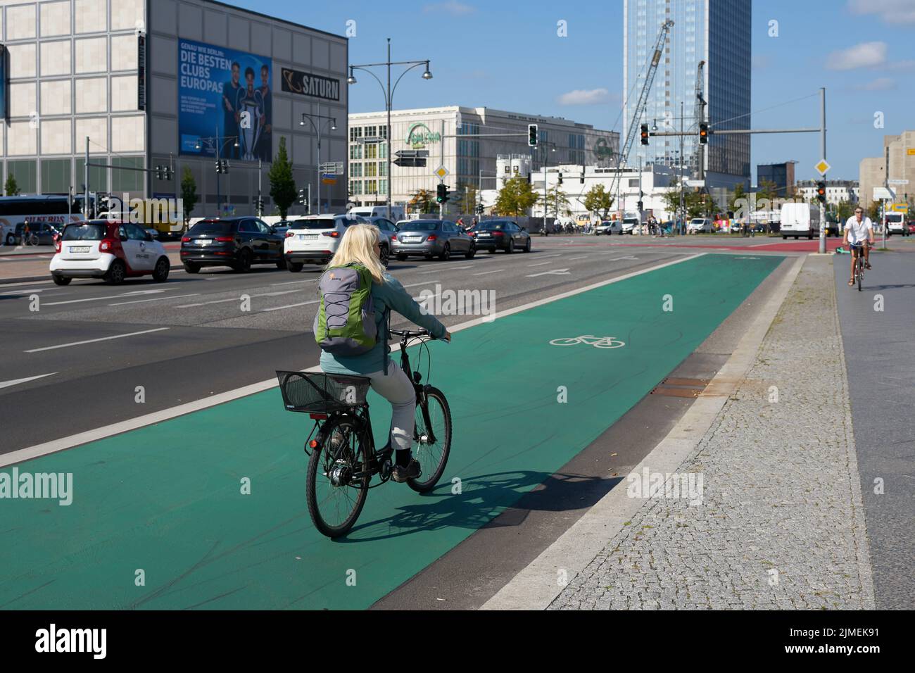 Female cyclist on a marked bicycle lane in the city center of Berlin ...