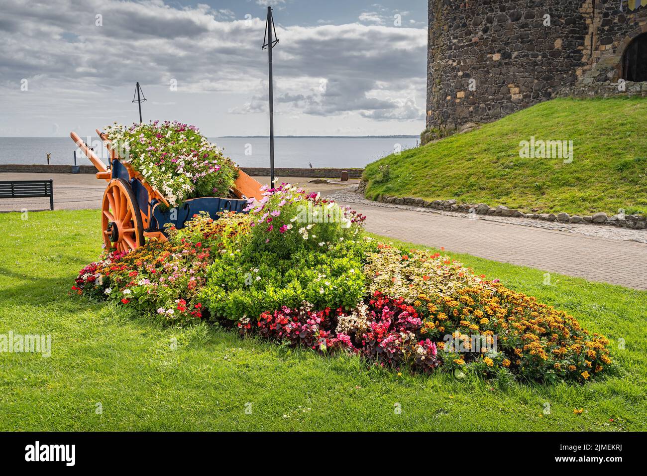 Flower pot made out of carriage and flower bed in front of ...