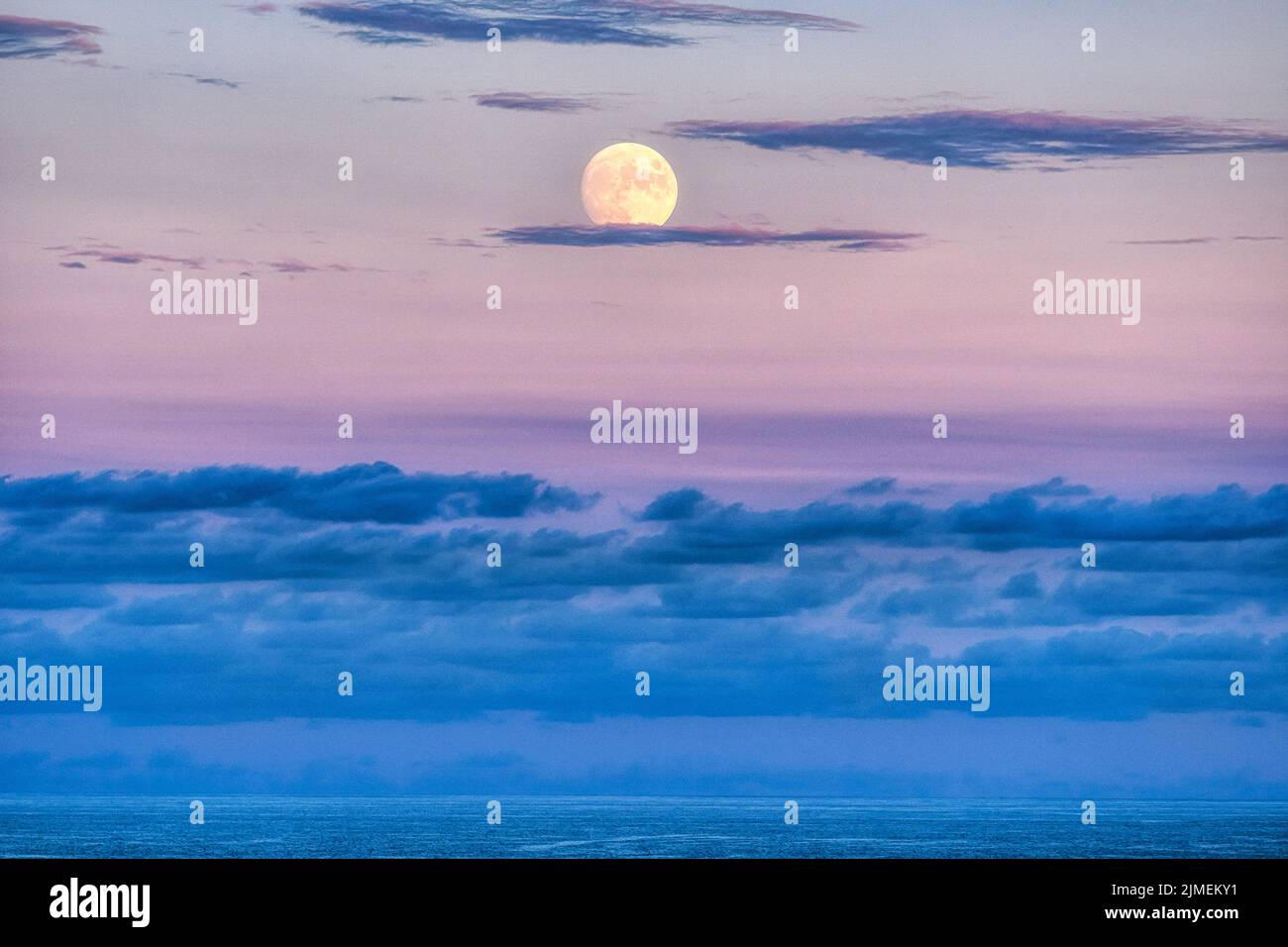 Sunset lit full moon Stock Photo - Alamy