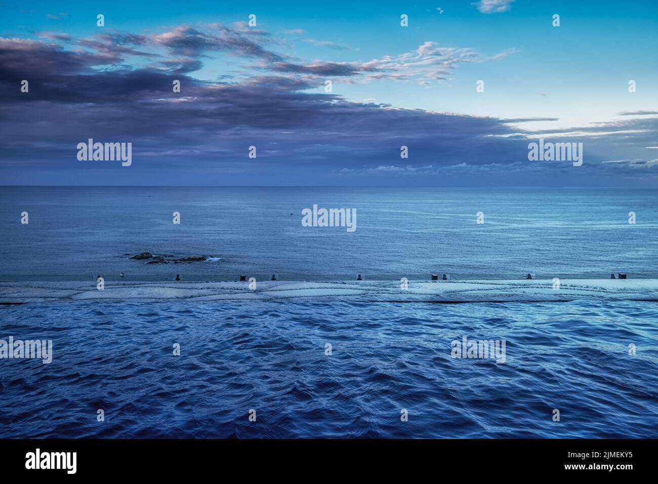Infinity pool by the ocean Stock Photo - Alamy