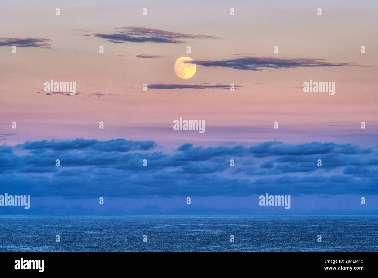 Sunset lit full moon Stock Photo - Alamy