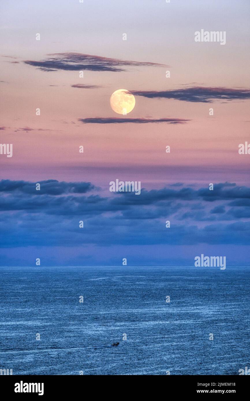 Sunset lit full moon Stock Photo - Alamy