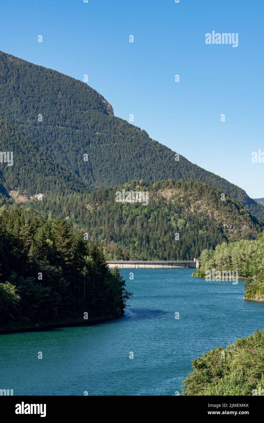 wide river winding between tree-lined shores leading to a distant dam ...