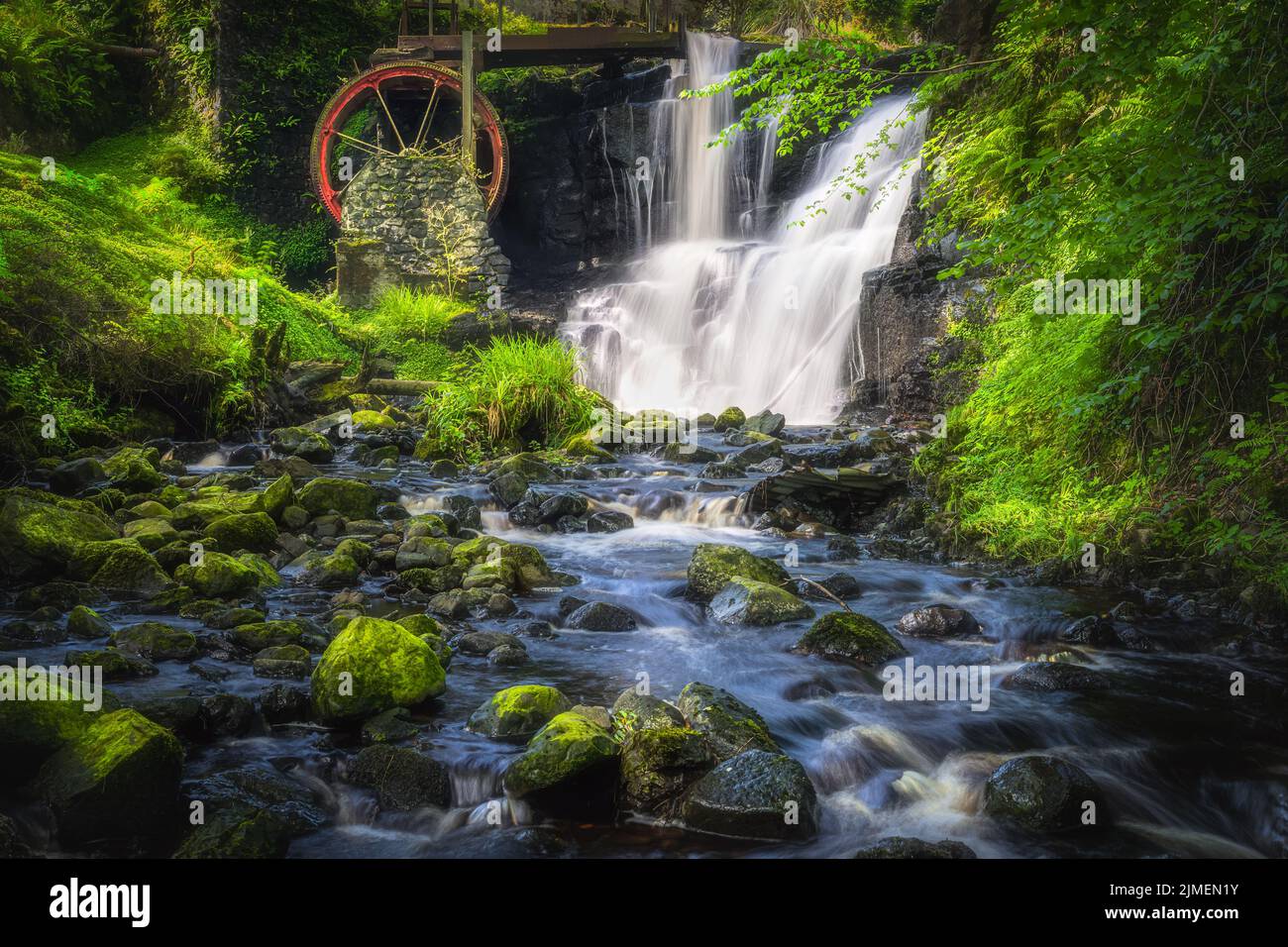 Mossy rocks in stream leading to waterwheel and waterfall in Glenariff ...