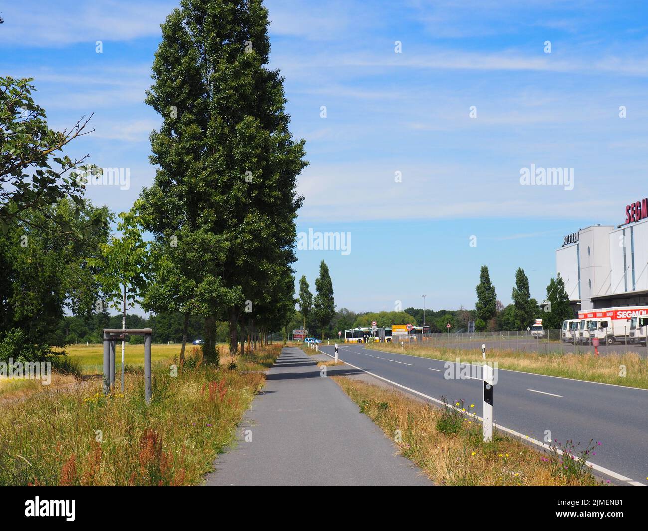 A street view with sidewalk, trees and warehouses in Weiterstadt ...