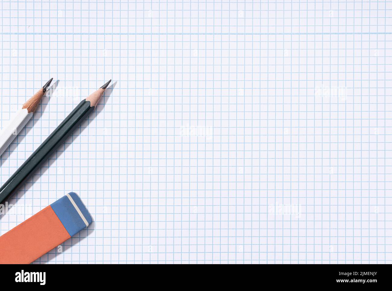 Pencils and eraser on blank Graph paper sheet background. Copy space ...