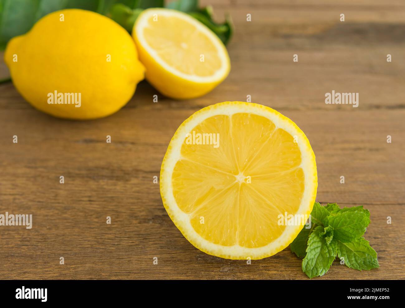 Lemon and lime cut pieces on a wooden floor Stock Photo - Alamy
