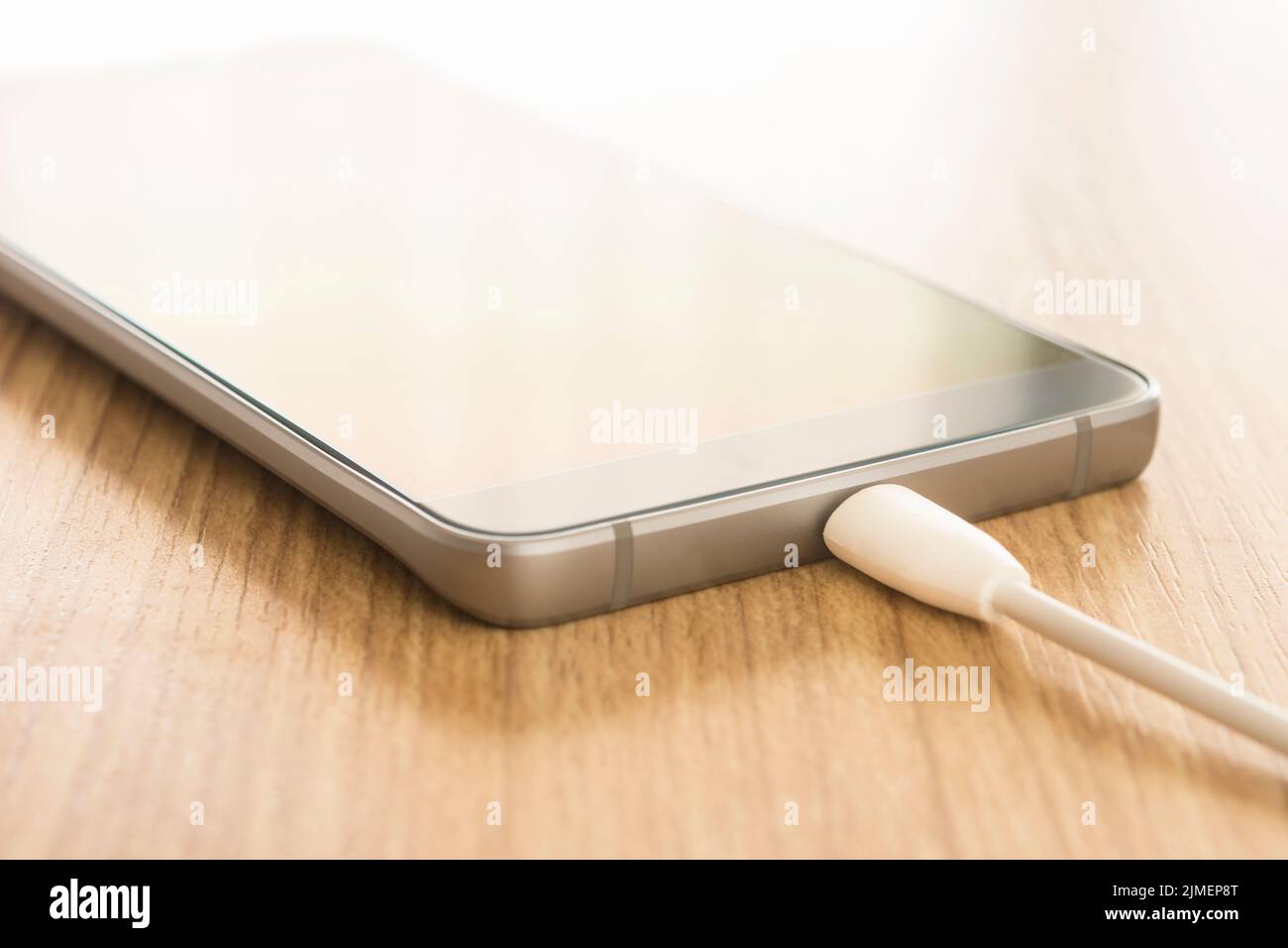 Mobile smart phones charging on wooden desk Stock Photo - Alamy