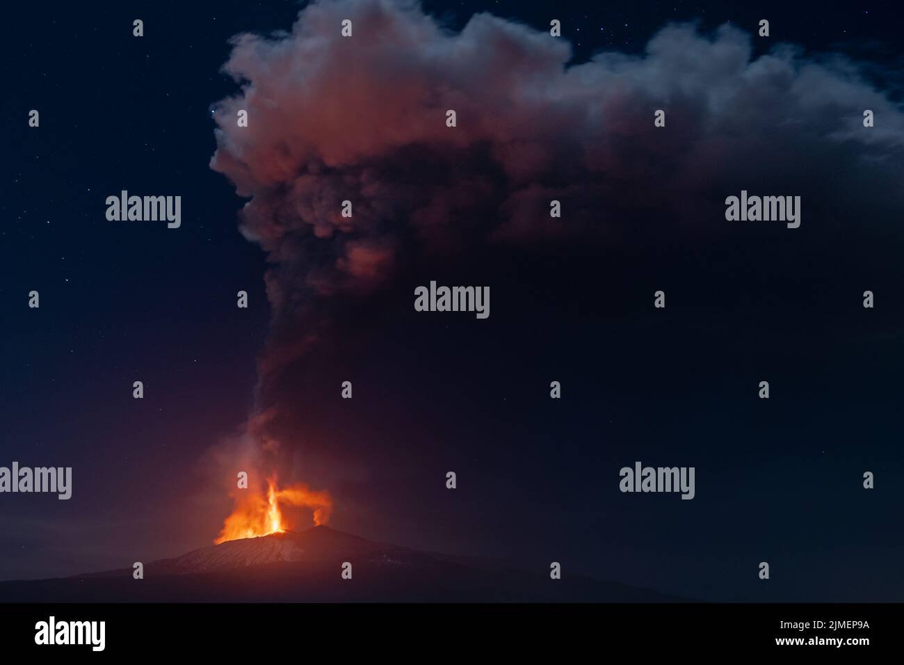 The view of an erupting volcano flames and smoke at night sky Stock ...