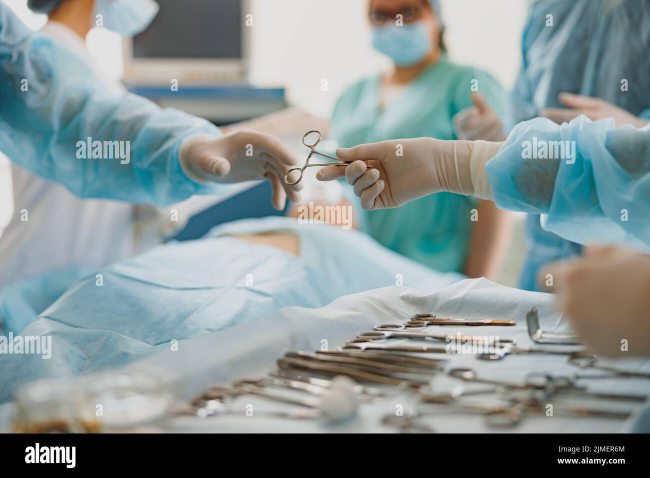 Assistant hands out instruments surgeon during surgery in the operating ...