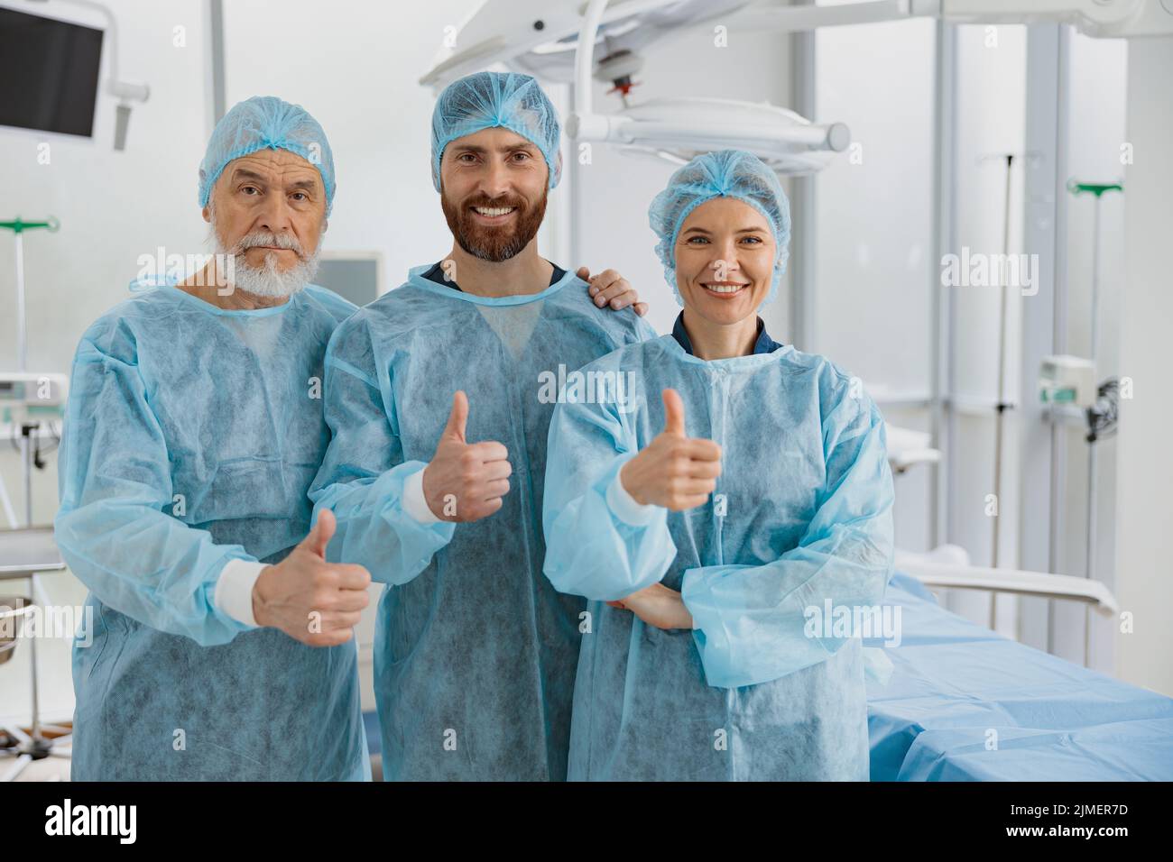 Team of professional surgeons shows thumbs up standing in operating ...