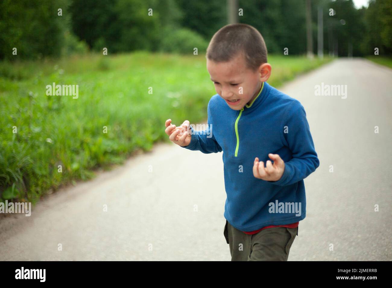 Child is angry. Boy threatens. Schoolboy swears in street. Negative ...