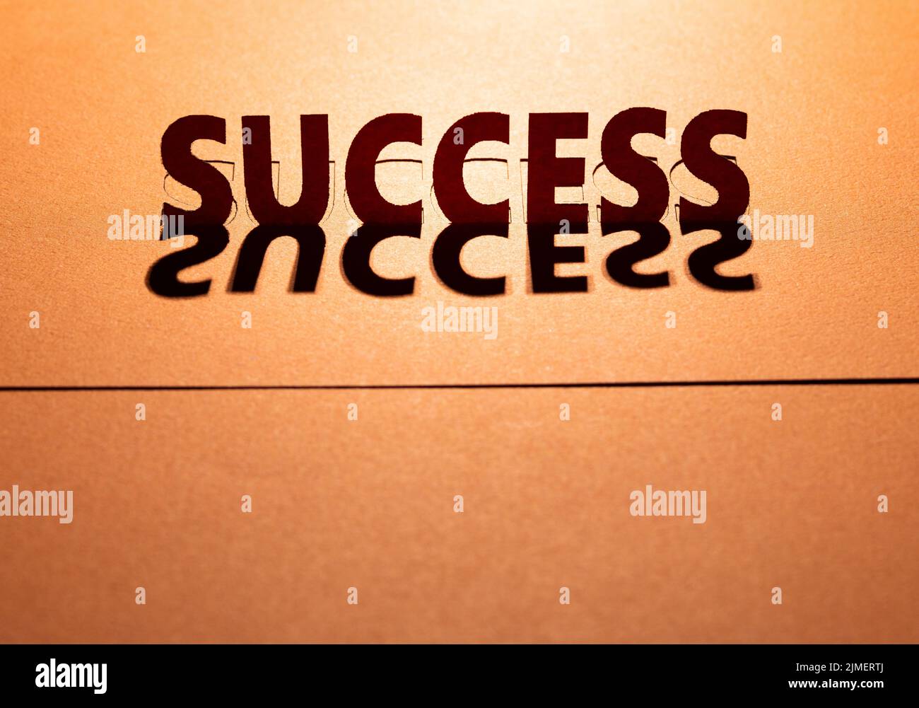 Success word cutting and standing from paper, lit from behind and ...