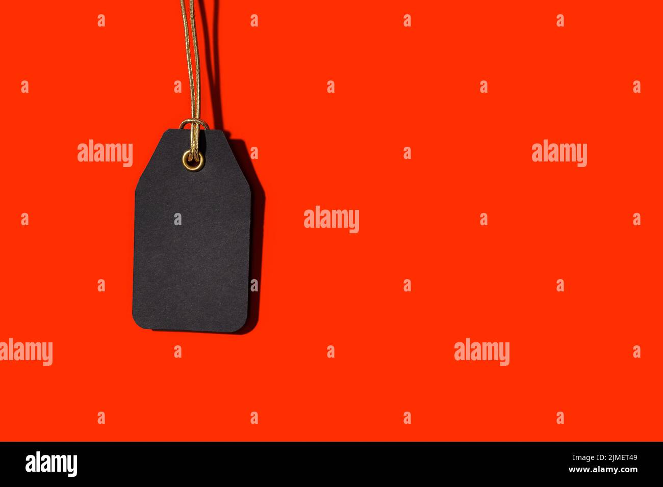 Blank black tag isolated on red background with copy space. Template ...