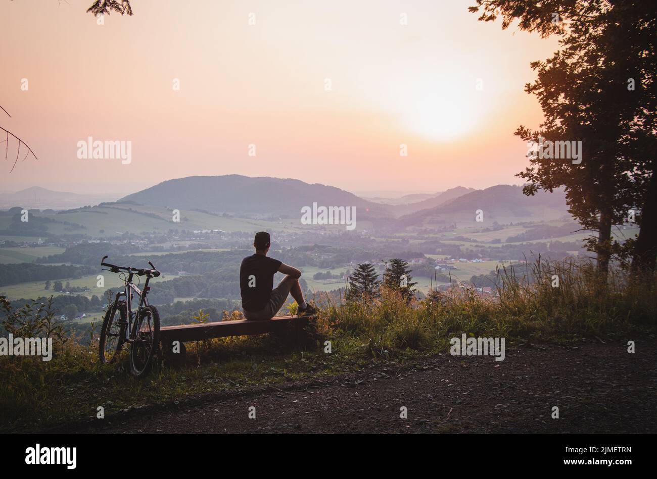 Active athlete sitting on a bench after going to the top of a hill on ...