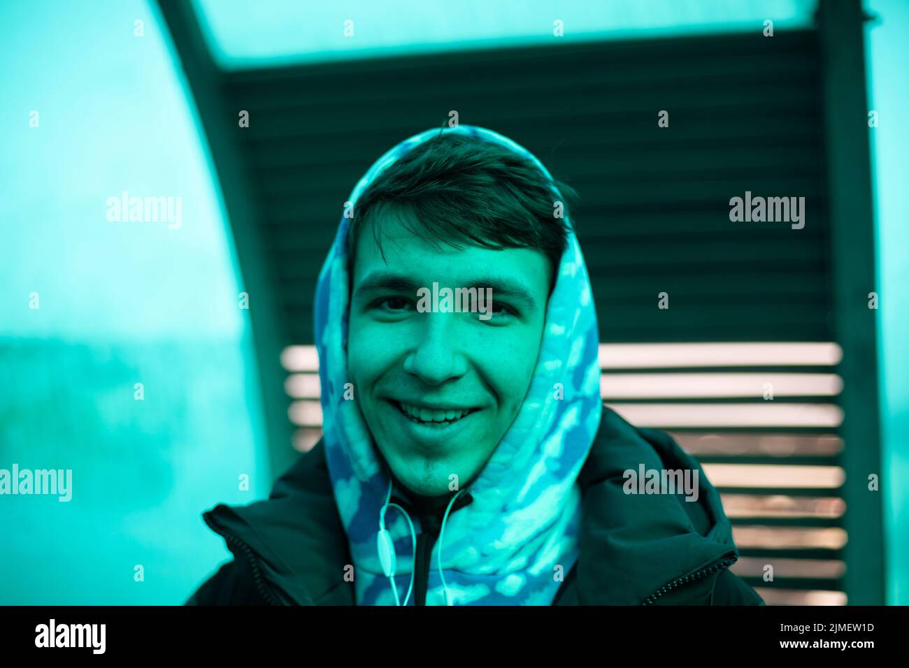 Blue portrait of guy. Man in blue filter. Student in hood. Smiling guy ...