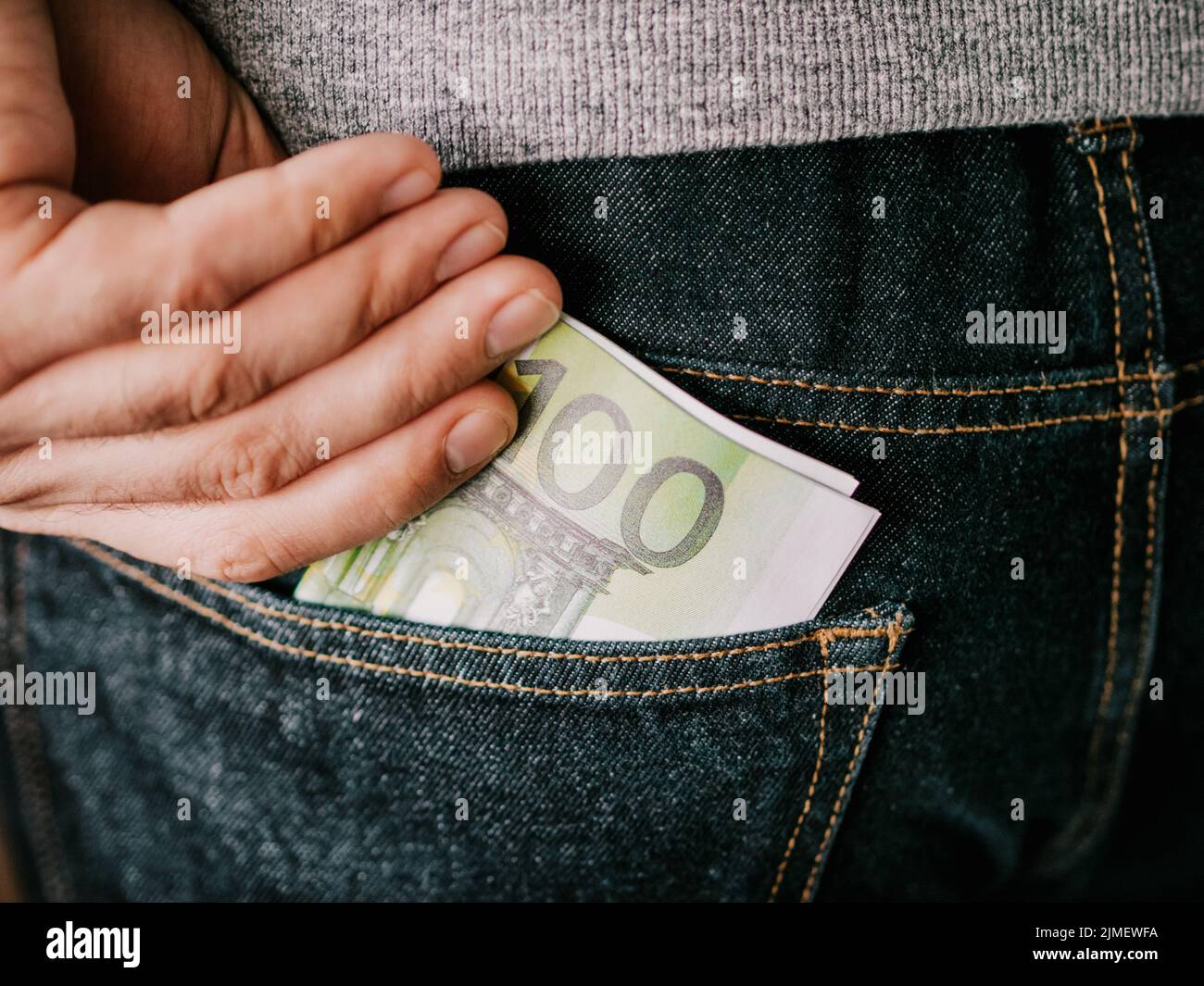 Hand put Euro in jeans pocket Stock Photo - Alamy