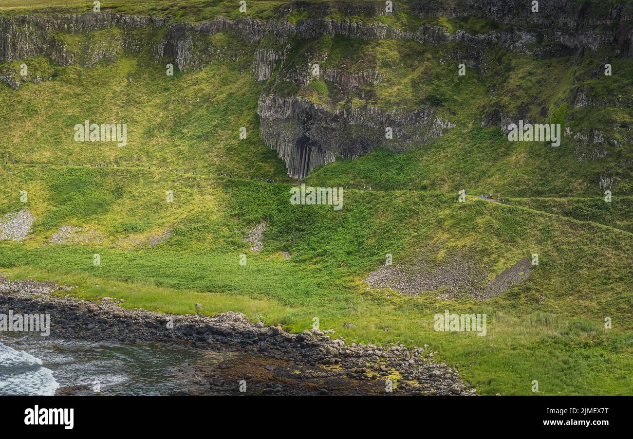 Tourists admiring The Amphitheatre in Giants Causeway, Northern Ireland ...