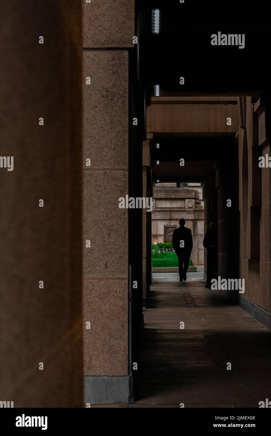 A vertical shot of a male walking through the building walls Stock ...