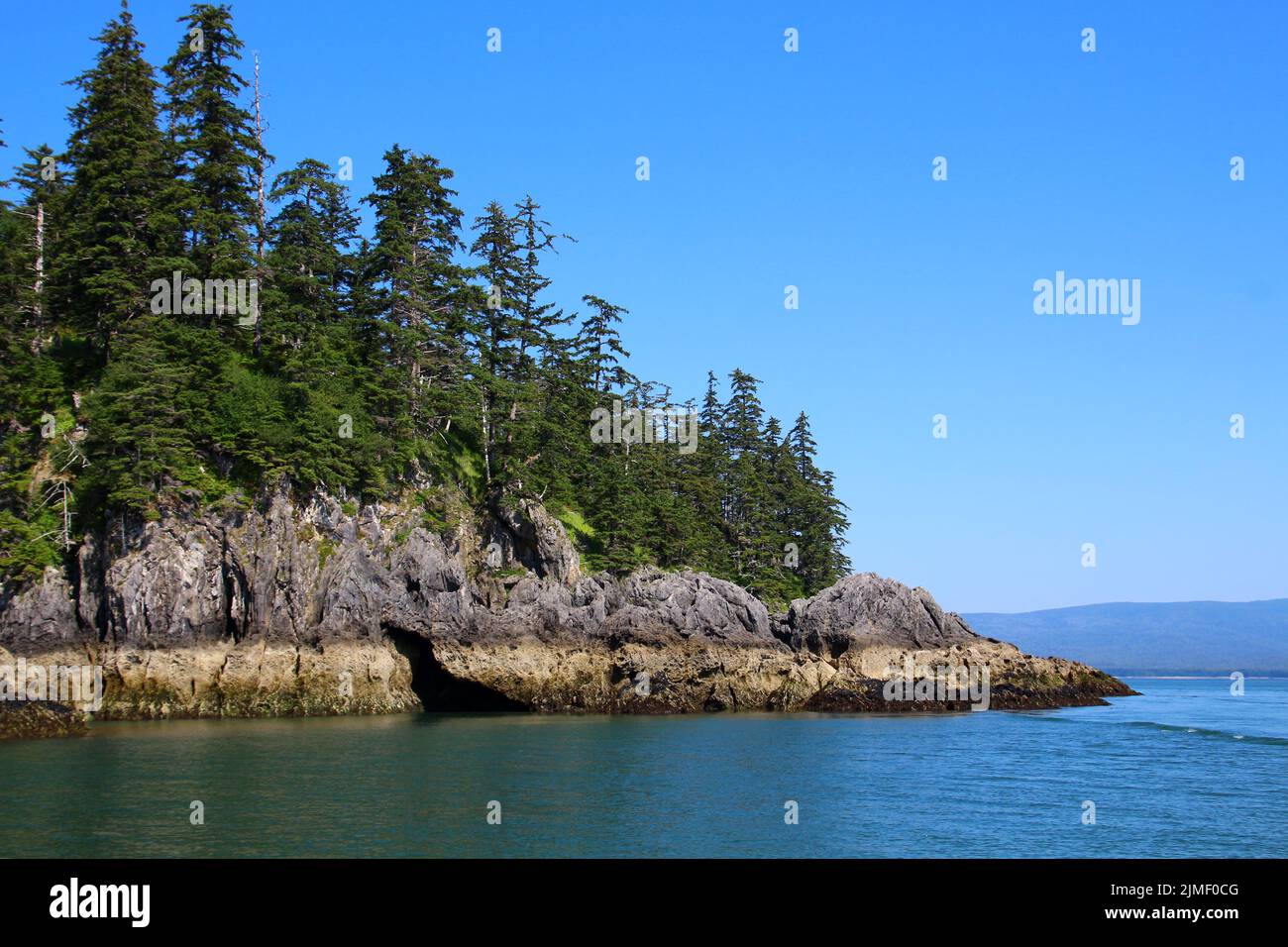 Alaska, Small tree-covered island in the waters near the small town of ...