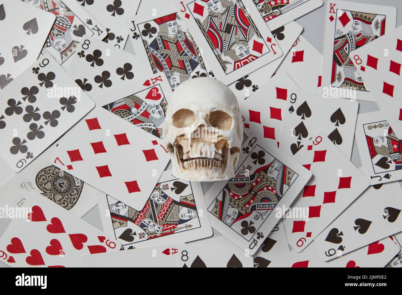 Skull on scattered playing cards Stock Photo - Alamy