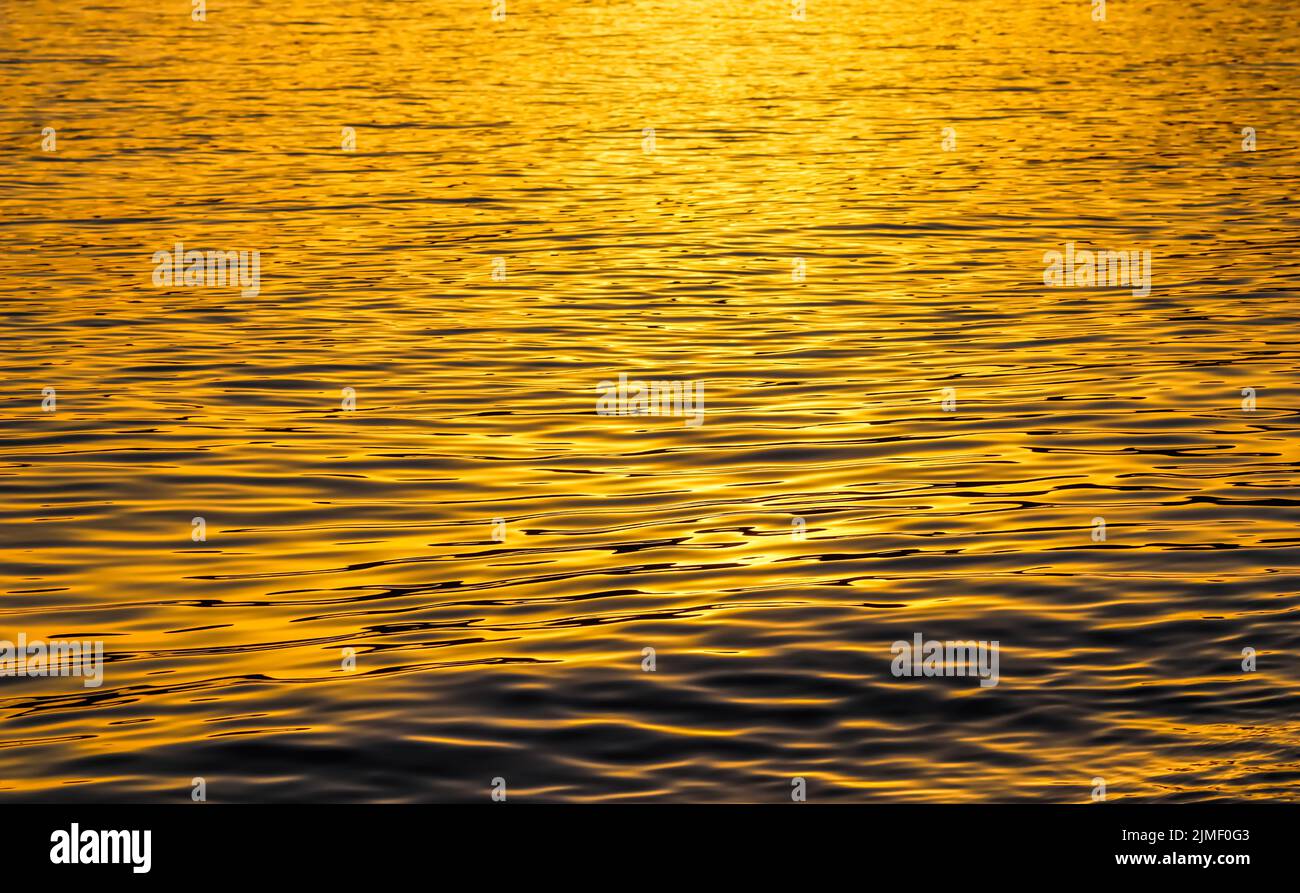 Golden sea waves in sunset glow as surface background. Summer holidays ...