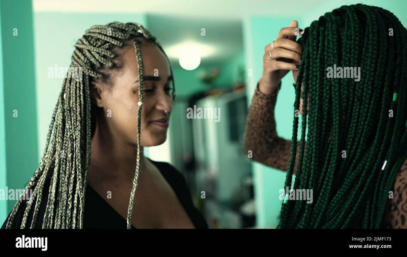 Two young black latina women showing their braided hair. Hispanic girls ...