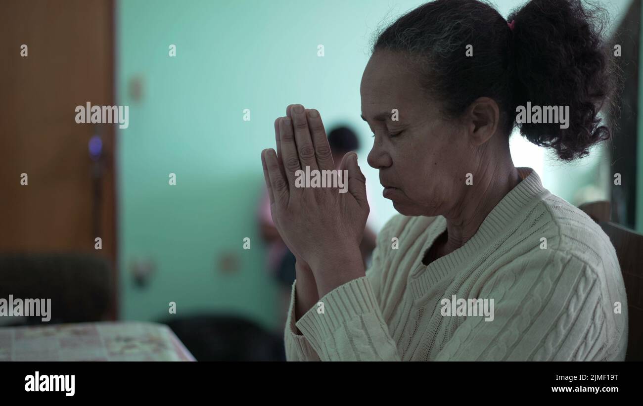 Spiritual older woman praying to God at home. Grateful senior lady ...
