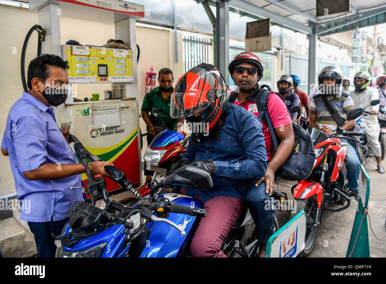 A pump attendant refuels a bike at a Petrol station in Dhaka. The ...