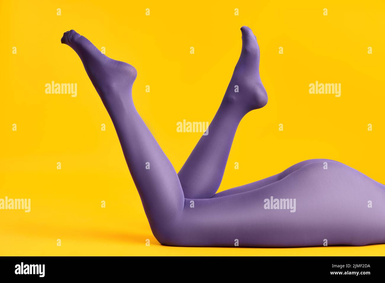Slim legs of beautiful young woman in bright purple tights relax on ...