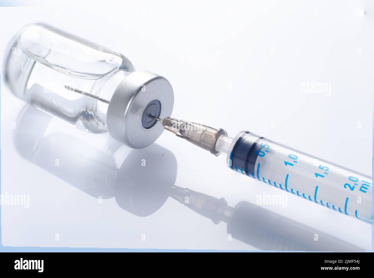 Just opened vaccine vial with inserted syringe for injection treatment ...