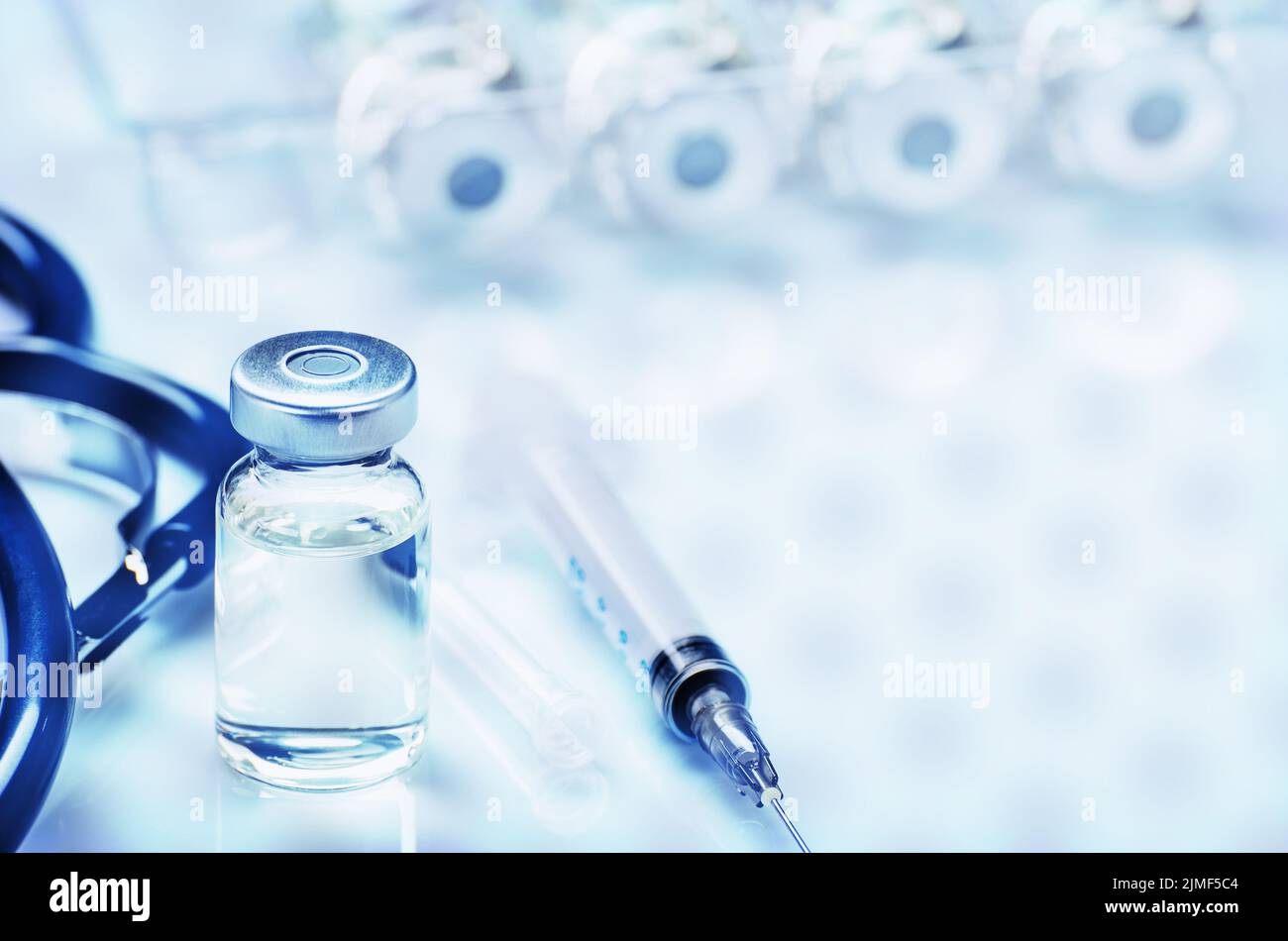 Vial with liquid drug as vaccine dose flu shot along with stethoscope ...