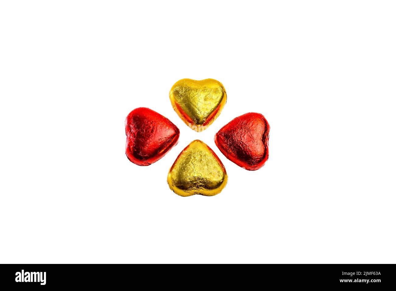 Heart shaped chocolates wrapped in red and gold yellow foil on white ...