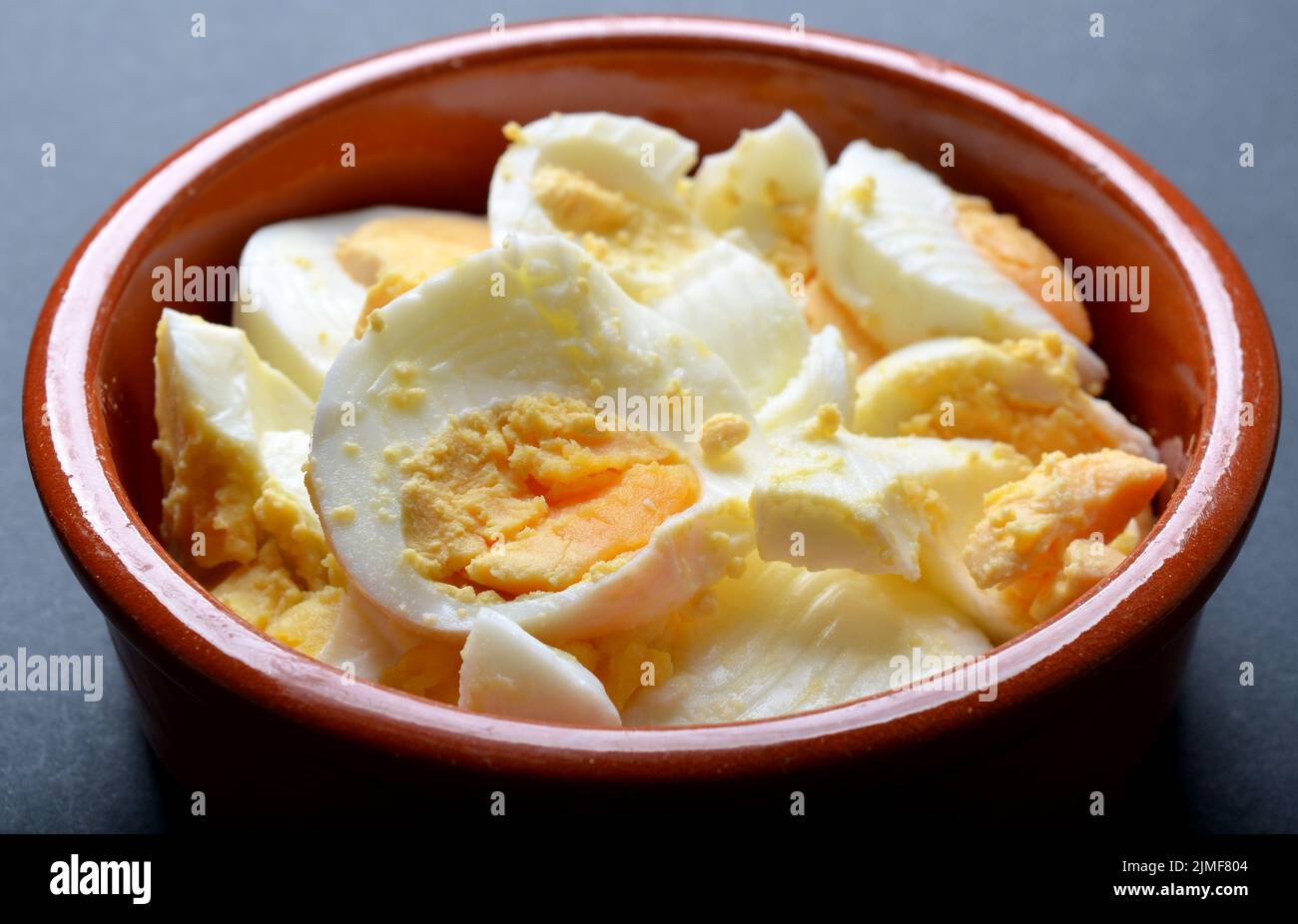 Pieces of hard boiled egg chopped in a bowl Stock Photo - Alamy