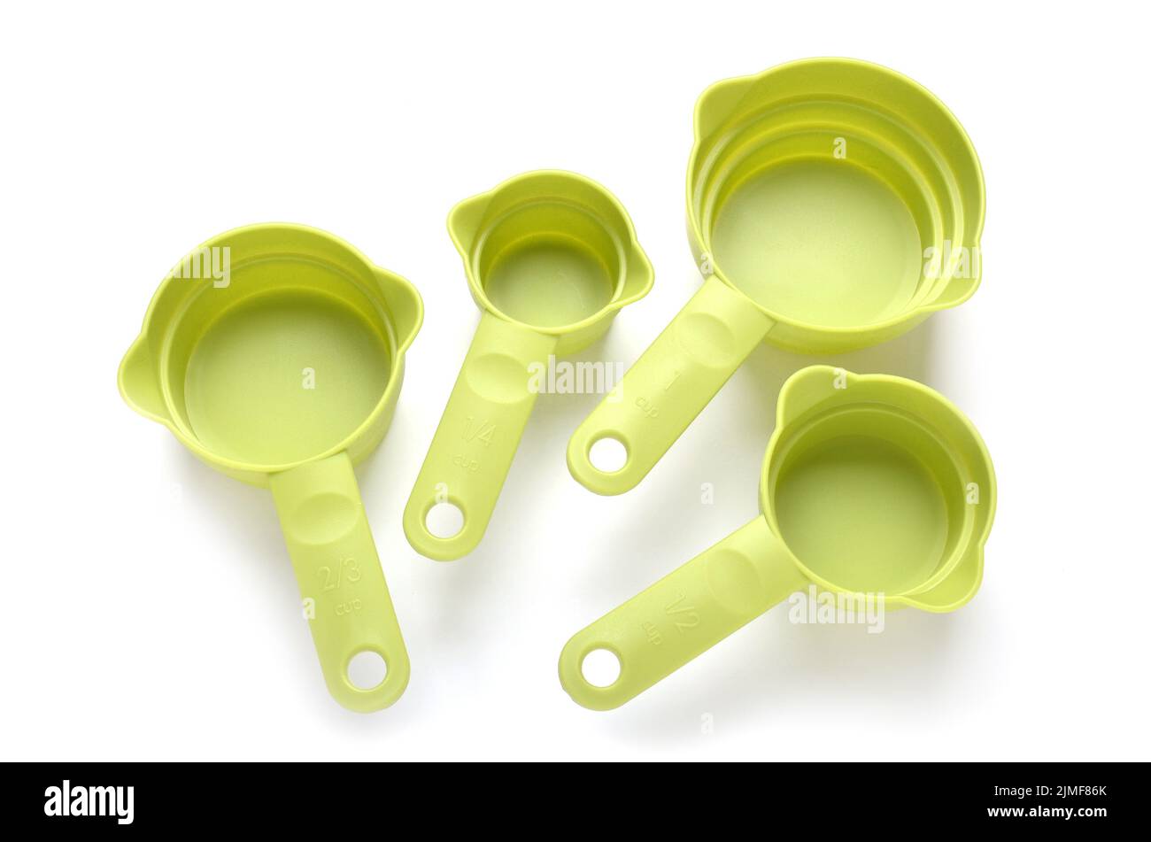 Set of green plastic measuring cups used in baking or cookery isolated ...