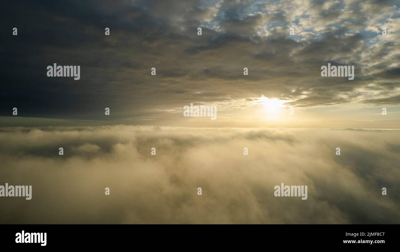 Aerial View. Flying in fog, fly in mist over the early morning clouds ...