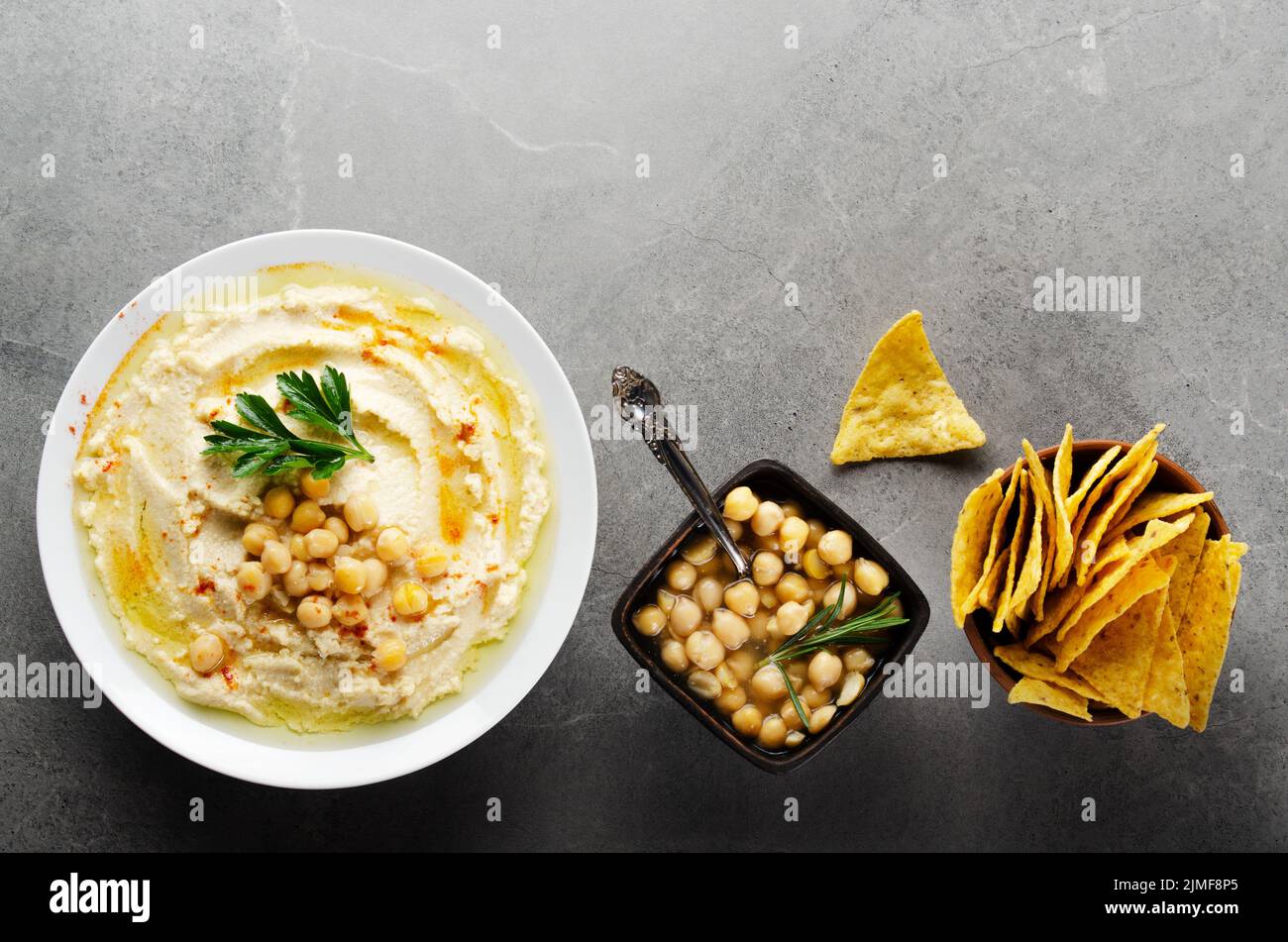 Flat lay Hummus in clay dish topped with chickpeas and green coriander ...