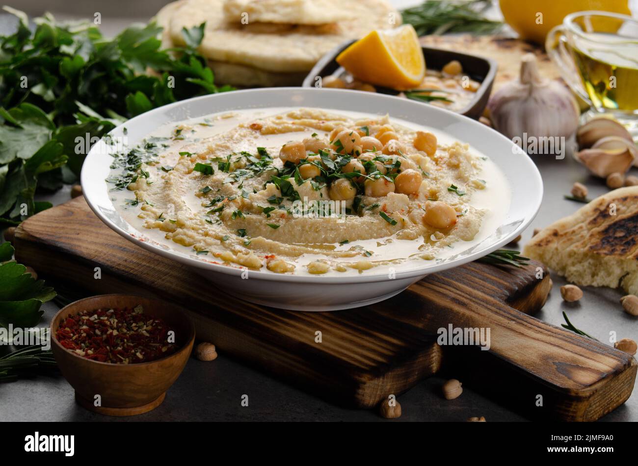 Fresh homemade Hummus in clay dish topped with olive oil, chickpeas and ...
