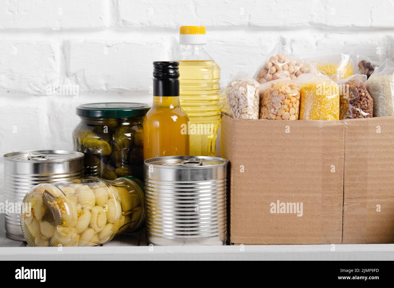 Set of uncooked foods on pantry shelf prepared for disaster emergency ...