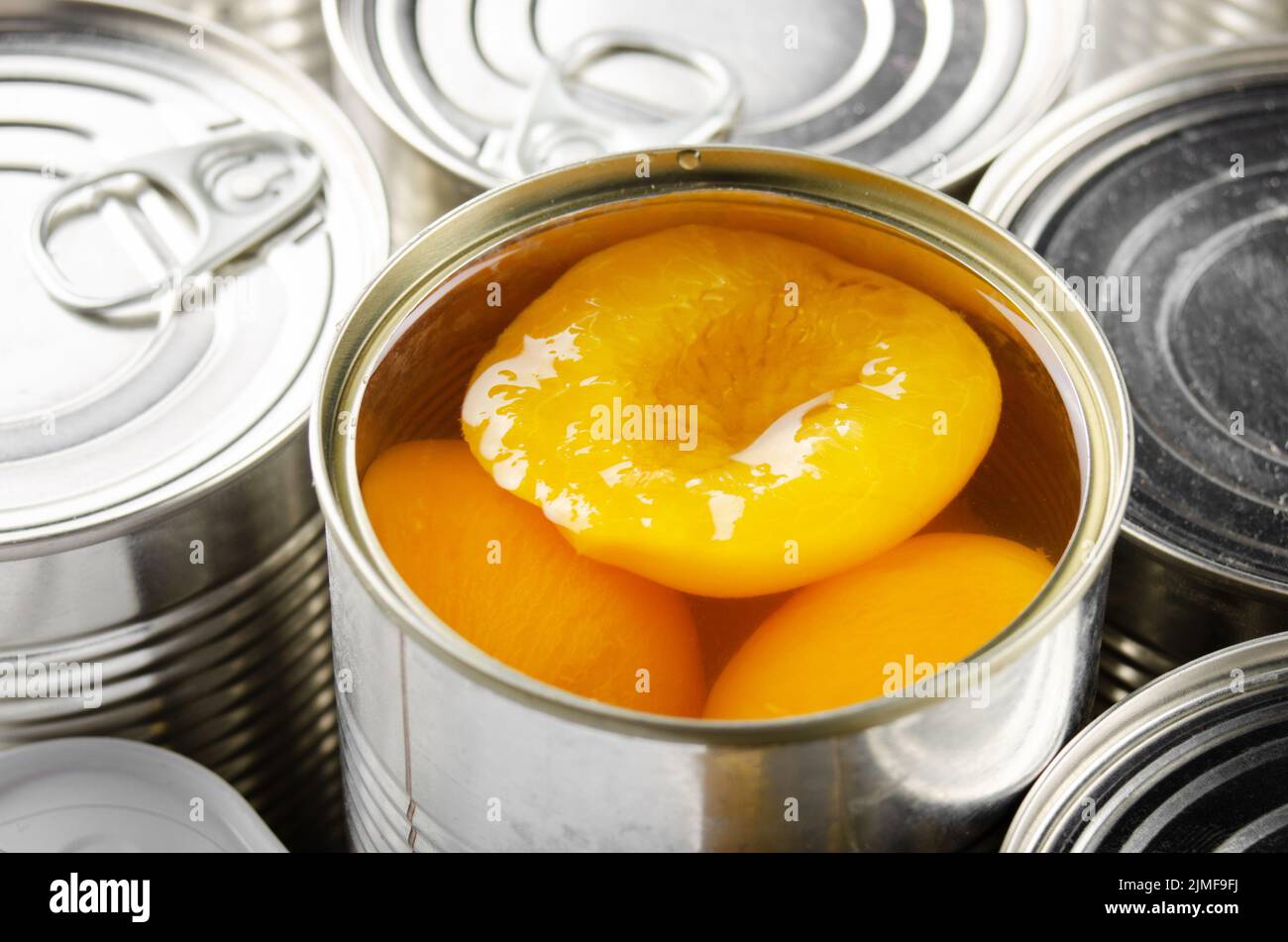 Canned peaches in just opened tin can. Non-perishable food Stock Photo ...