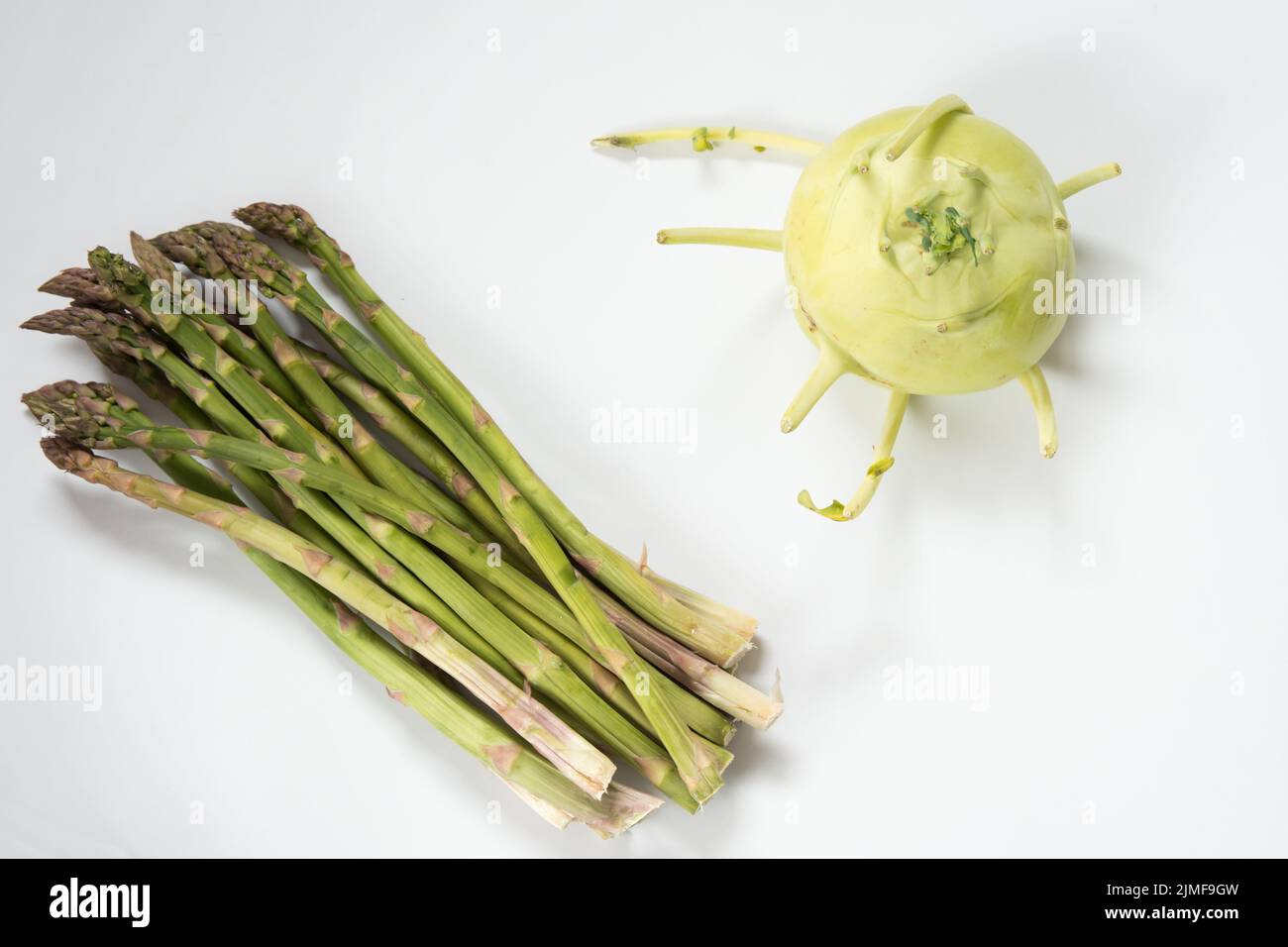 Kohlrabi, also known as german turnip, and a bunch of asparagus. White ...