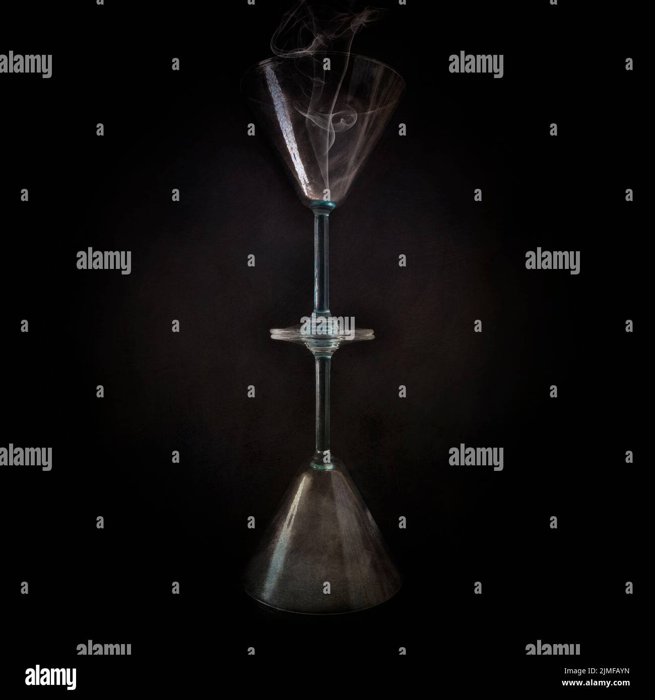two cocktail glasses, stack and containing smoke. The smoke is trapped ...