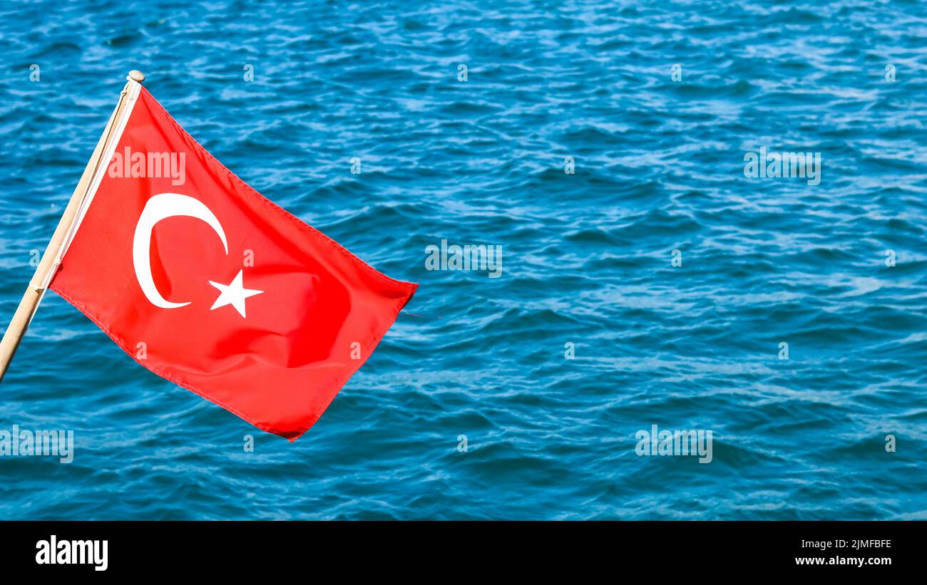 National flag of Turkey on a flagpole in the wind on a background of ...