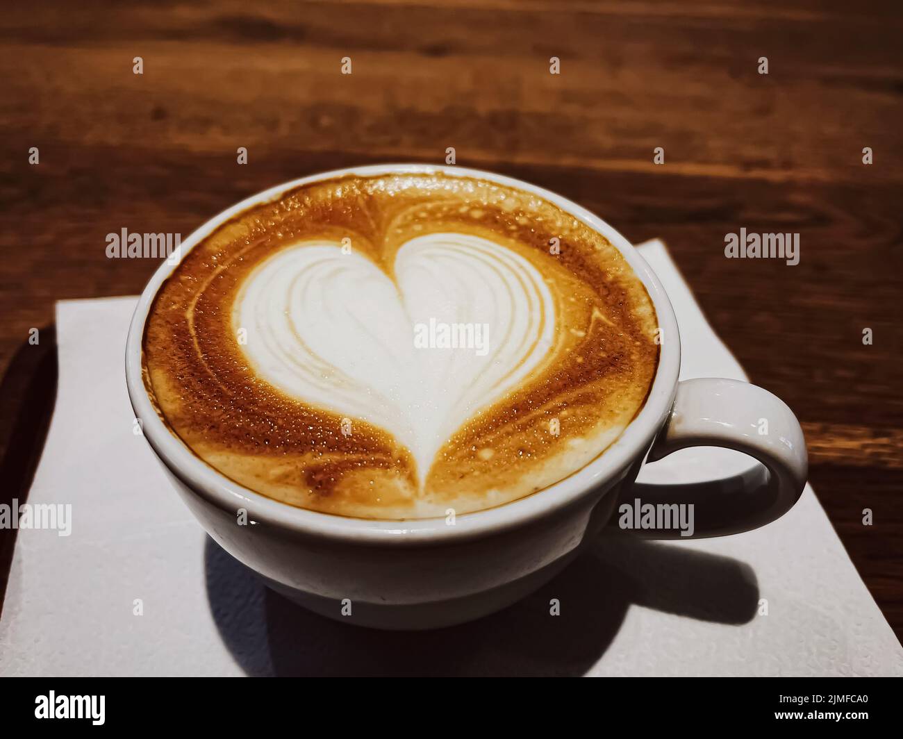 Coffee break and romantic mood concept. Cup of caramel cappuccino with ...
