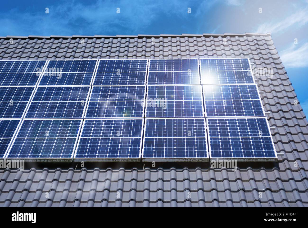 Roof photovoltaic panels under cloudy blue sky Stock Photo - Alamy
