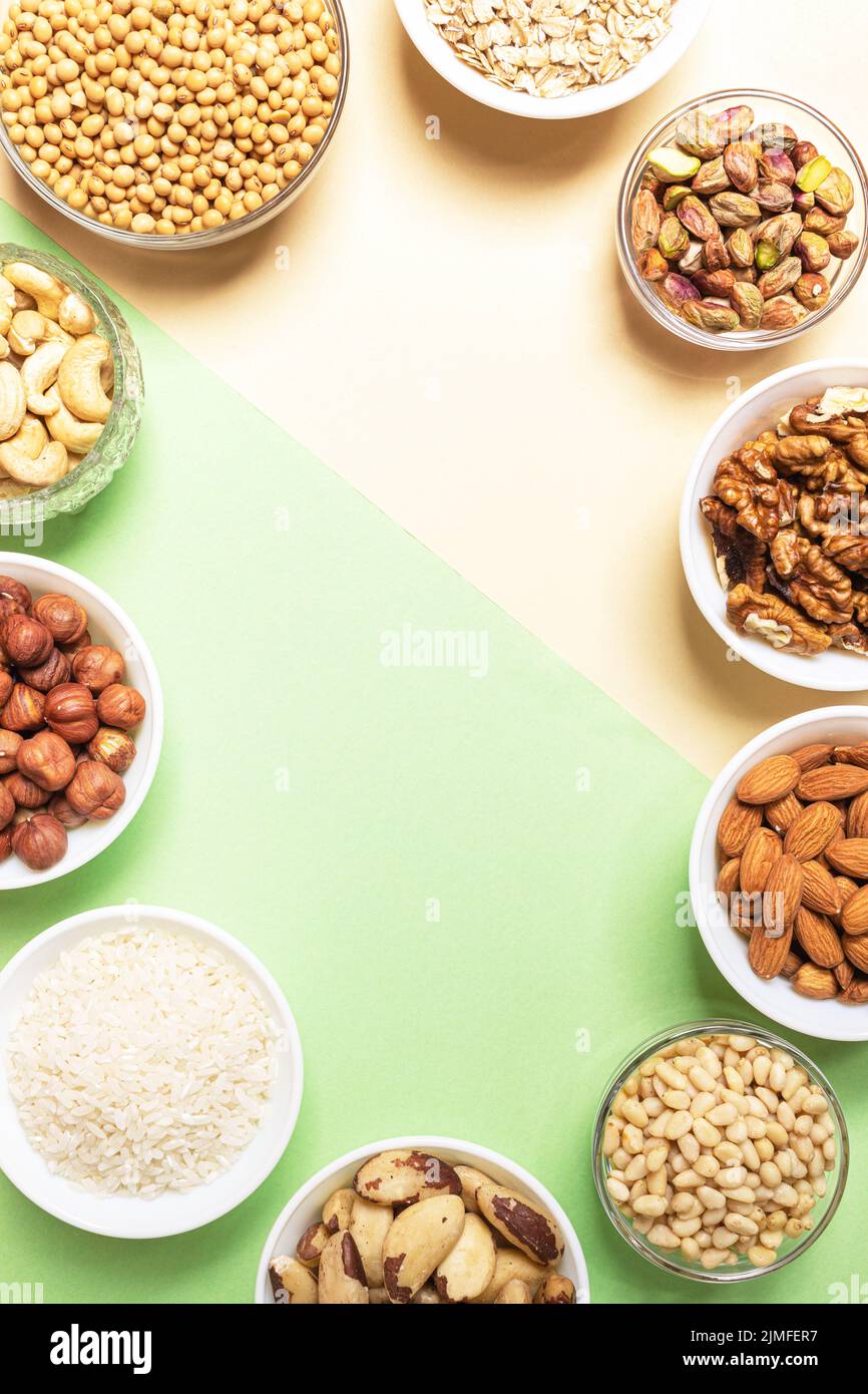Frame of bowls with cereals and nuts on two-tone beige-green backdrop ...