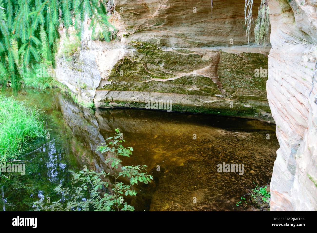 summer landscape with sandstone rock outcrop on the bank of a small ...